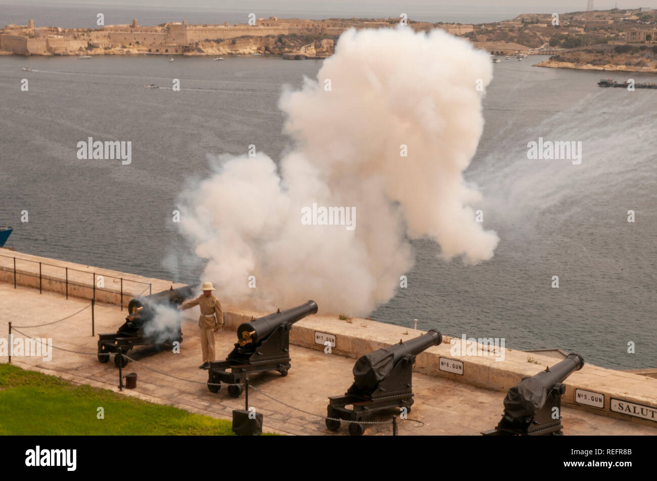 Soldier firing an old bronze cannon for the midday salute at the ...