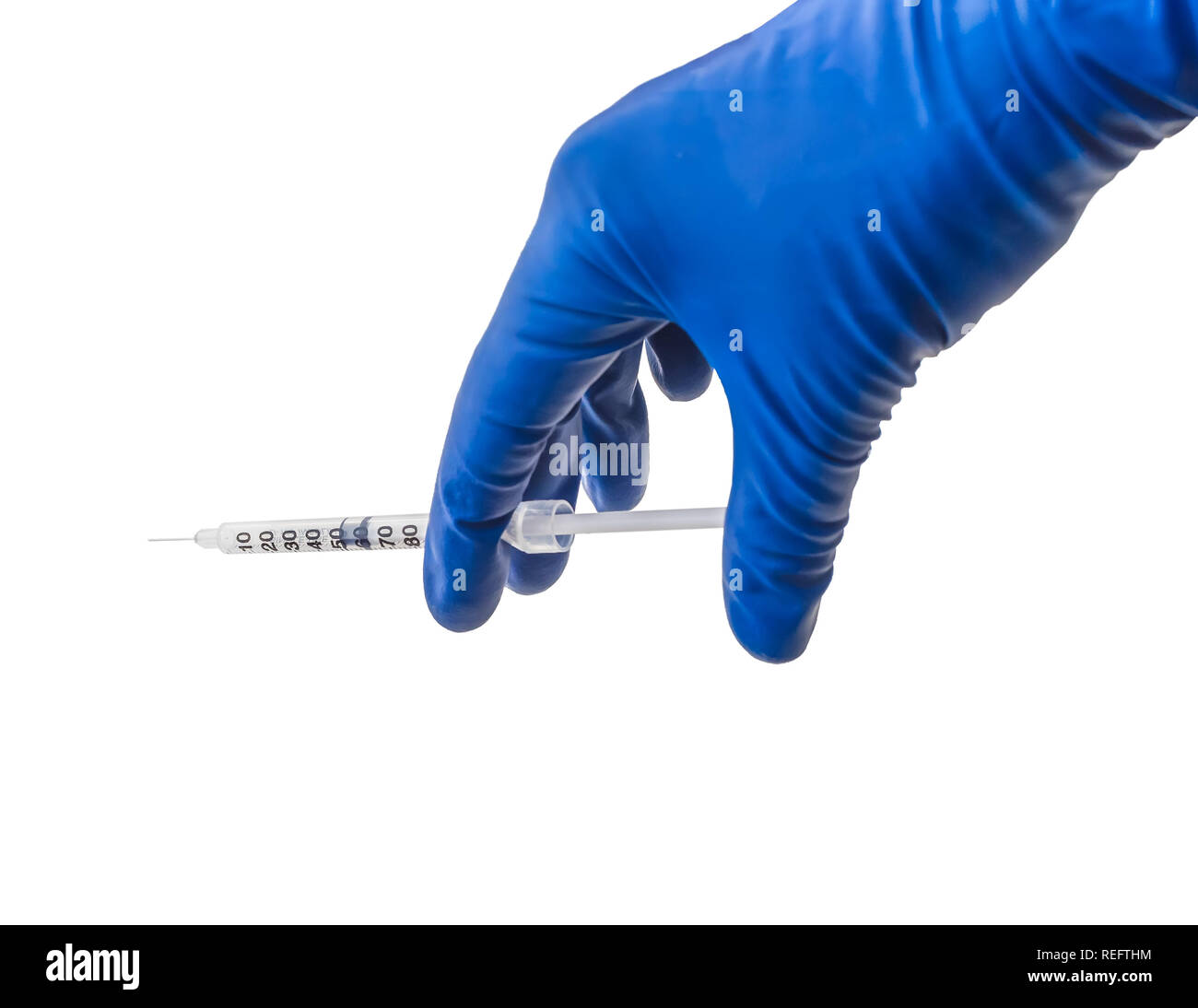 Doctor's hand in blue medical glove holding open syringe with medical ...