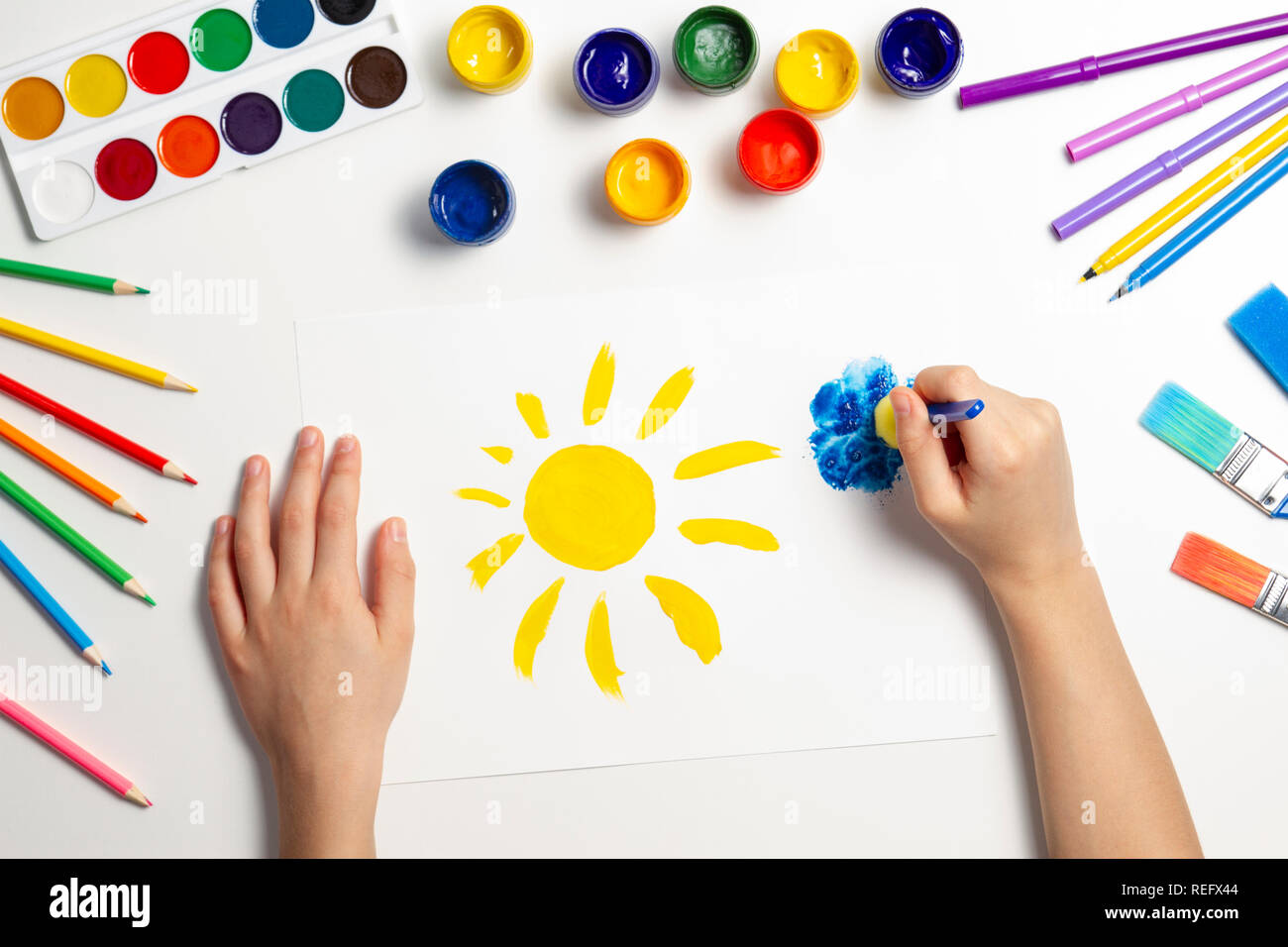 Kid hands painting at the table with art supplies, top view Stock Photo ...