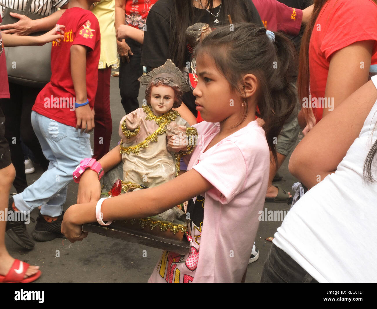 A child holding her Sto. Niño during the Feast of the Sto. Niños in ...