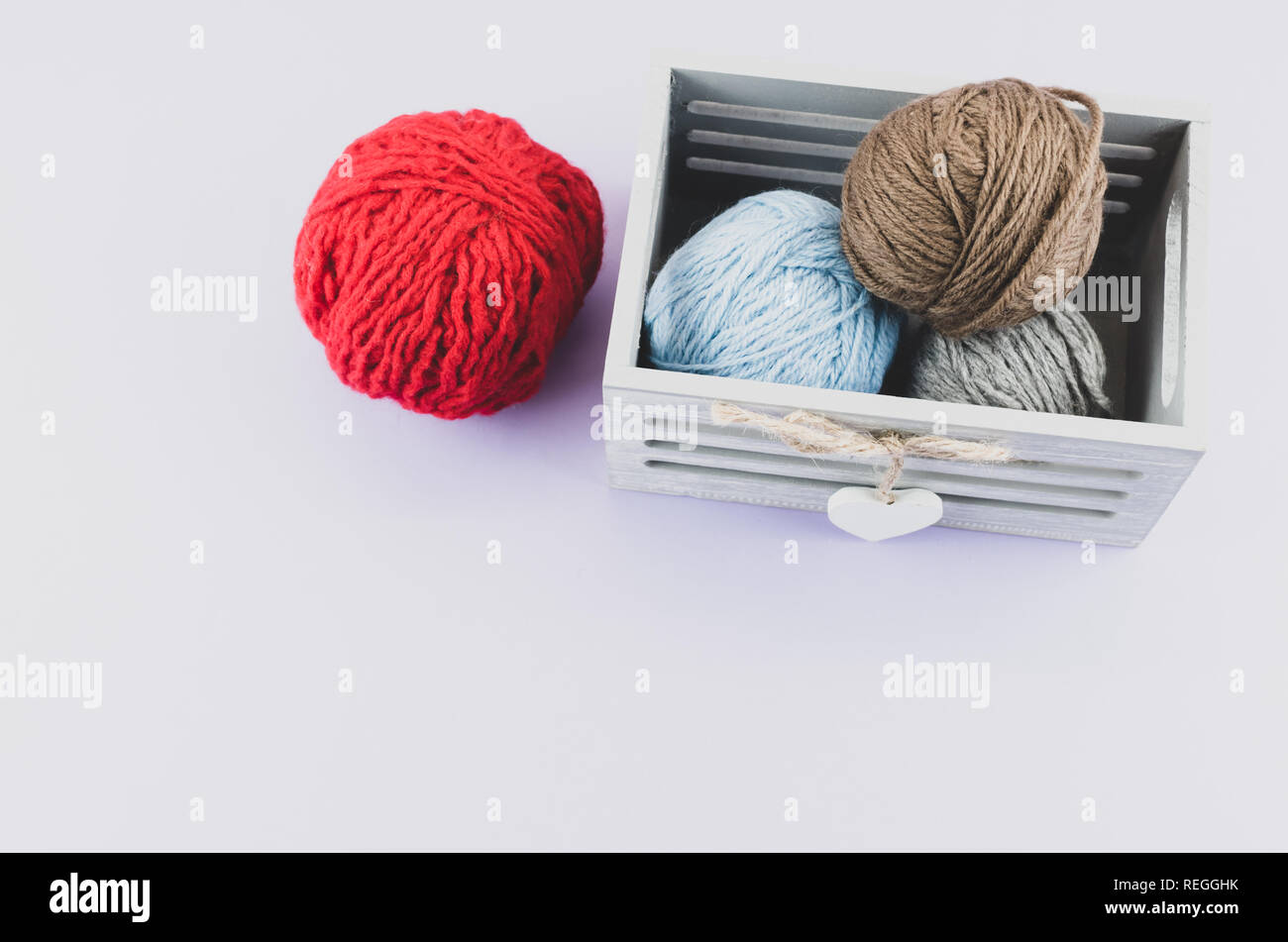 wooll balls and wooden basket still life on a white surface Stock Photo ...