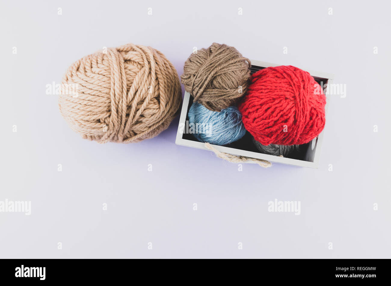 wooll balls and wooden basket still life on a white surface Stock Photo ...
