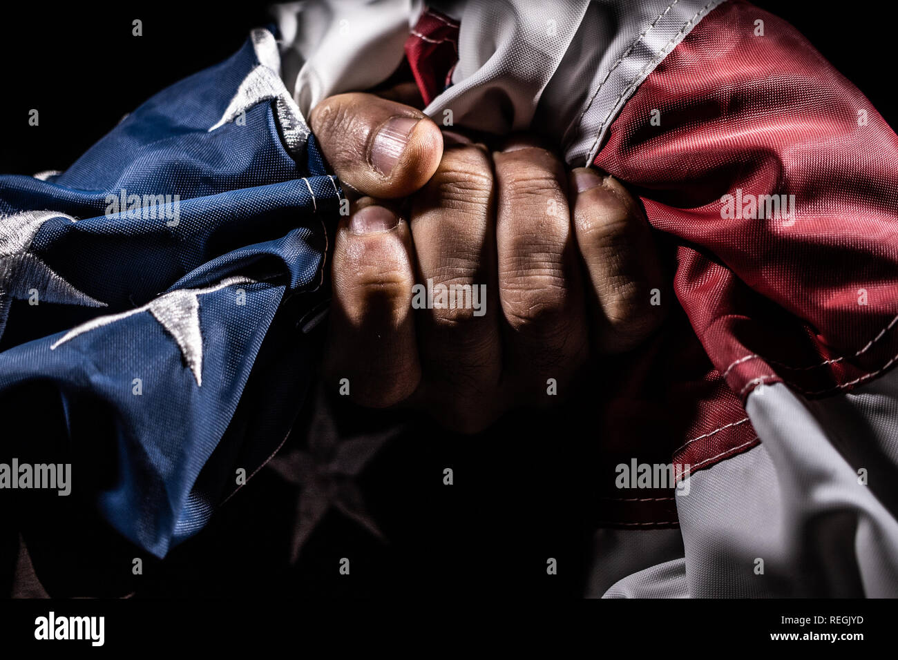 Male Hand Clutching American Flag (U.S.) with Dramatic Dark Key Light ...