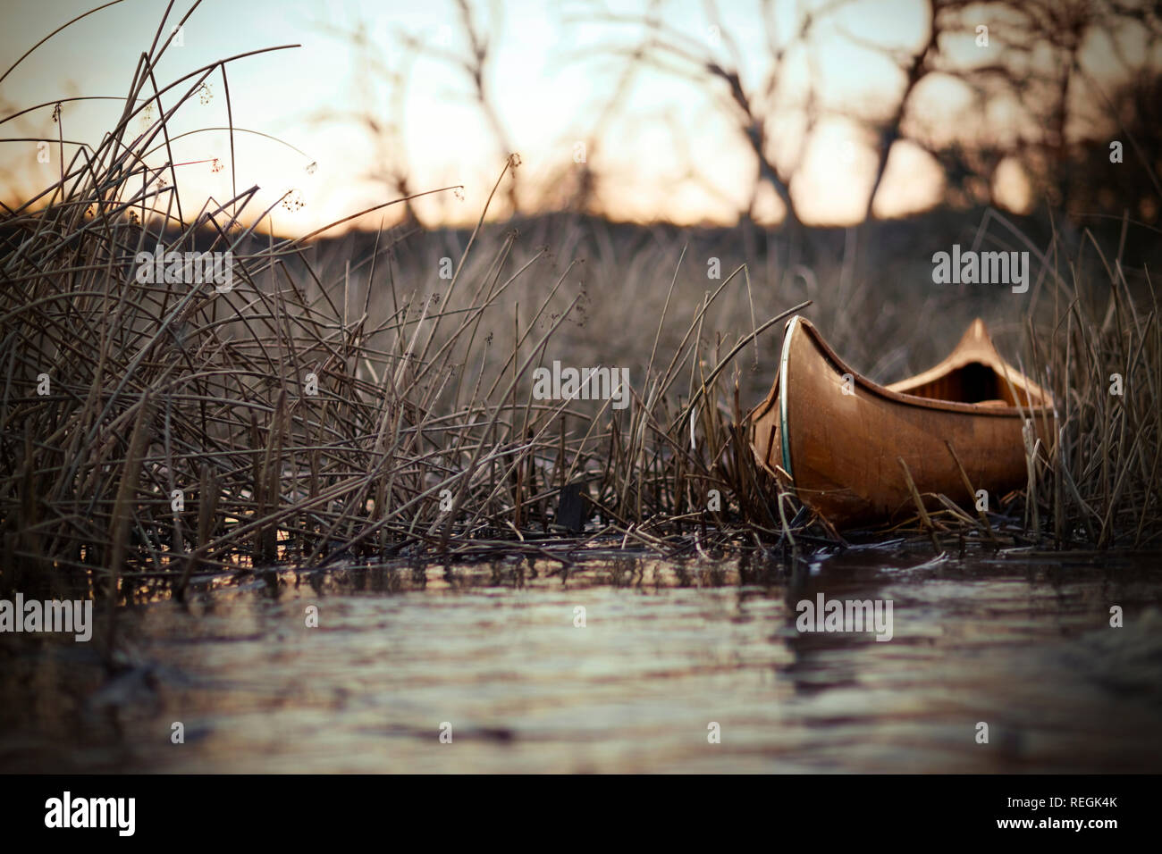 An empty canoe sitting on a lake Stock Photo - Alamy