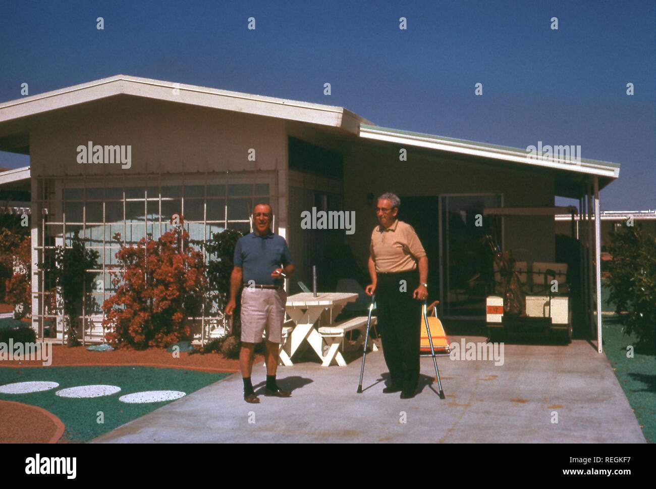 View of two men standing outside a contemporary ranch home at the ...