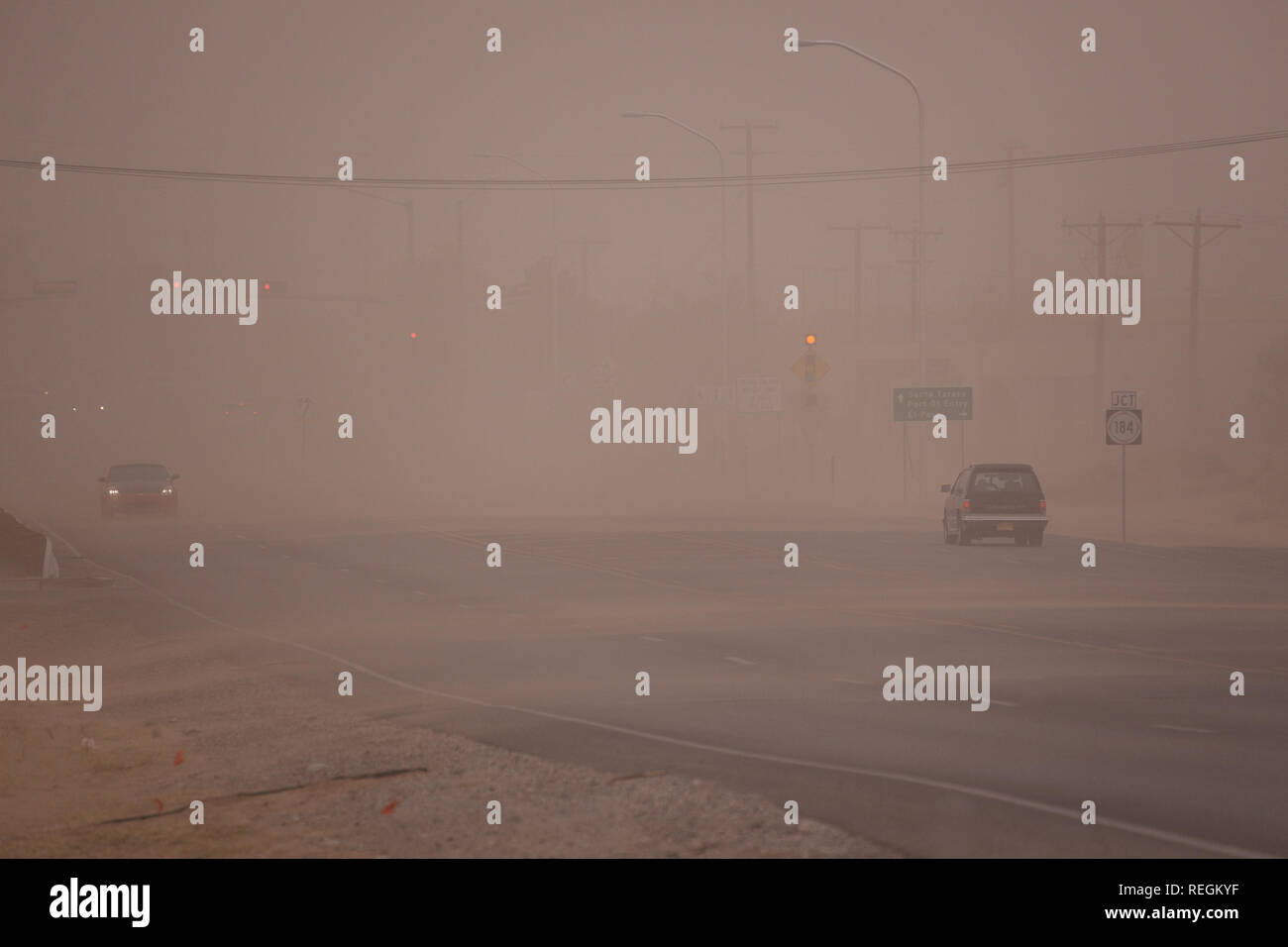 Cars navigate an intersection obscured by blowing and drifting dust in ...