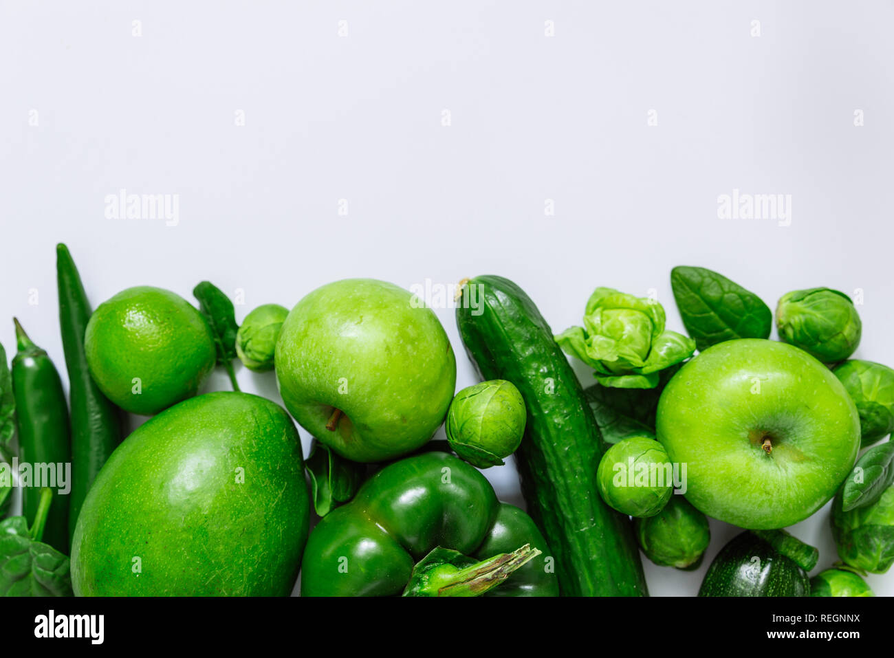 green fruits and vegetables on white background with copy space on top ...
