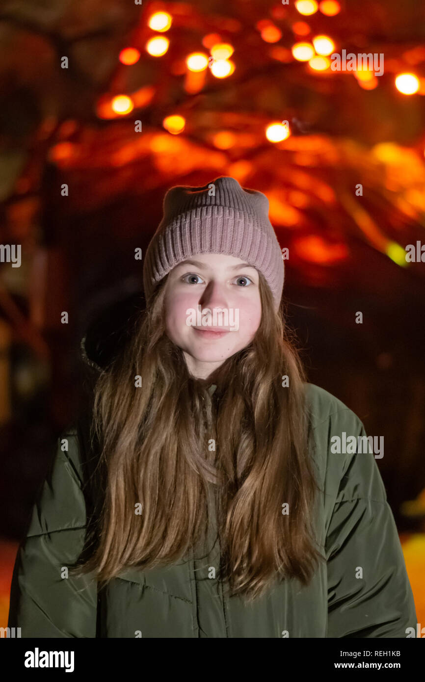 Beautiful girl looking down on the night city street against the ...