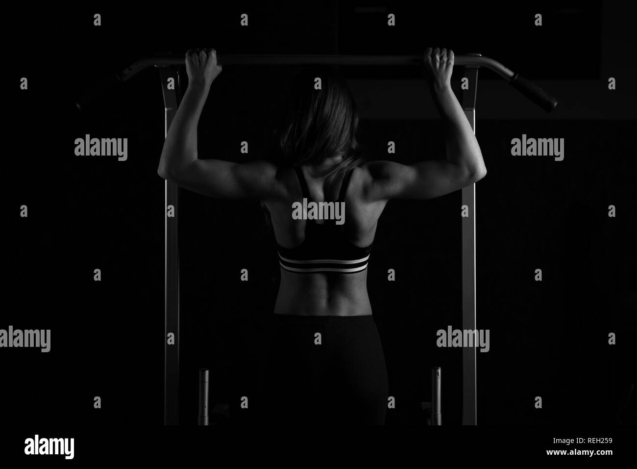 Fitness Shaped Muscle Woman doing pullups in gym black and white photo ...