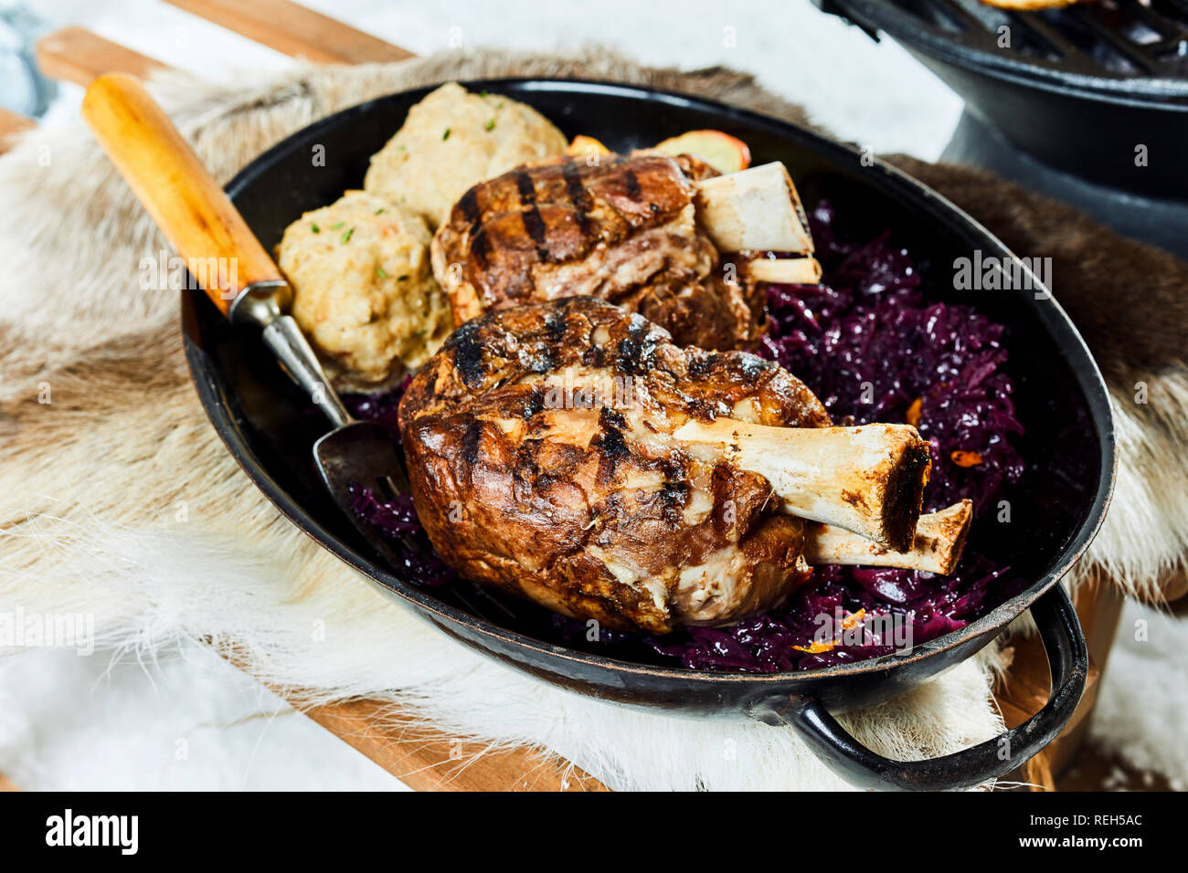 Winter barbecue with grilled pork hocks served with red cabbage and ...