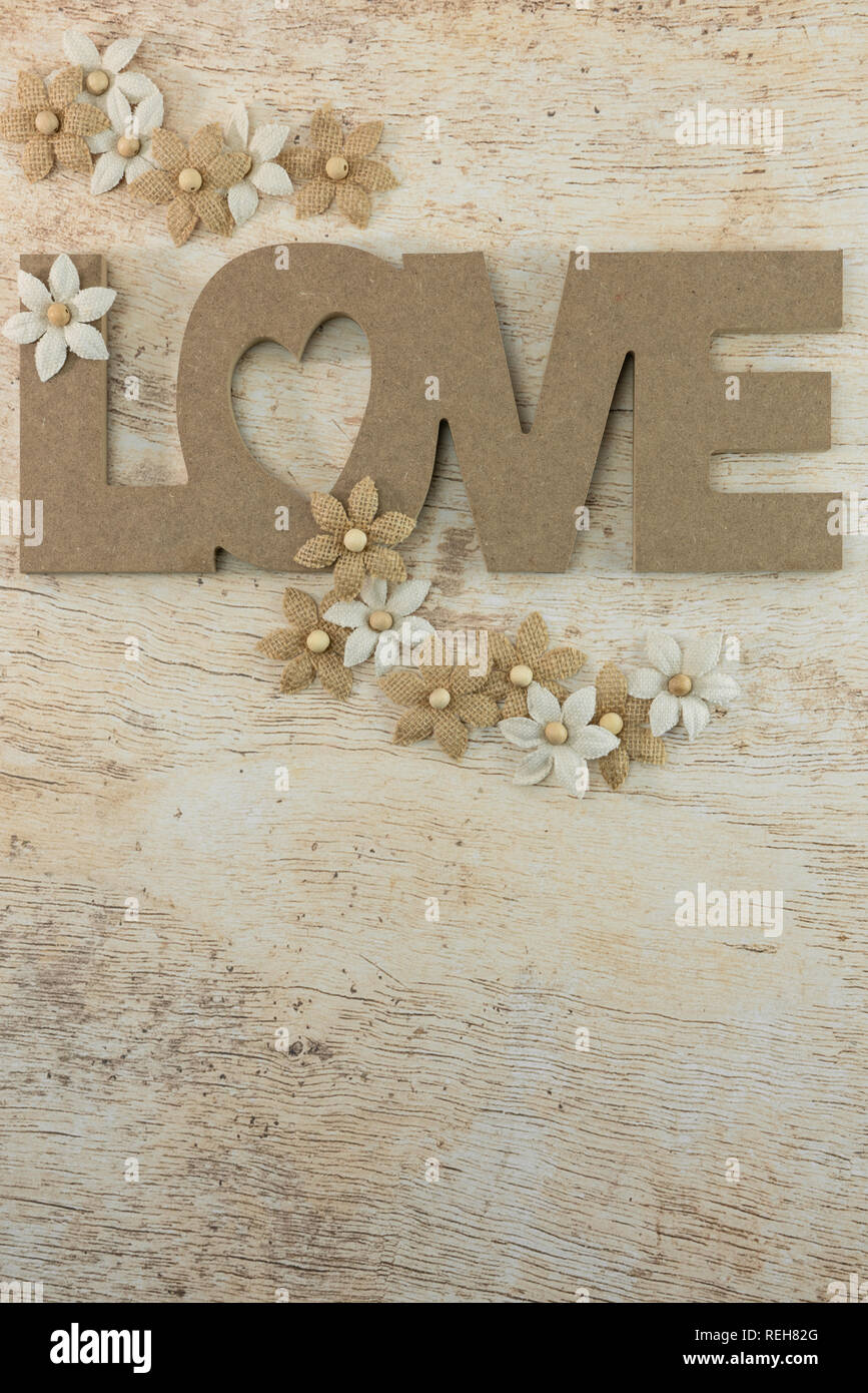 vertical love on a wood background with natural burlap flowers Stock ...