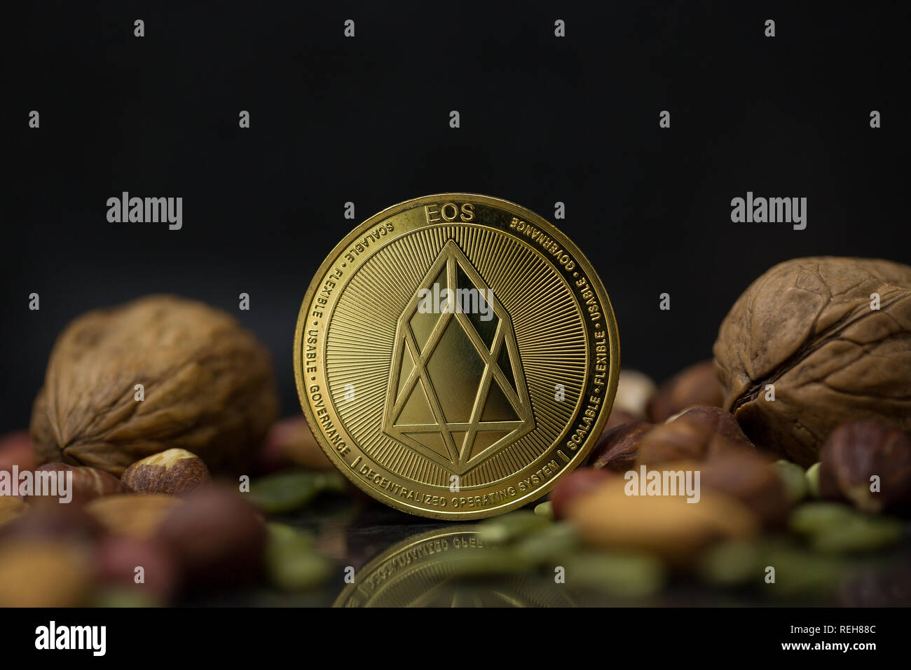Eos cryptocurrency physical coin surrounded with variety of nuts ...