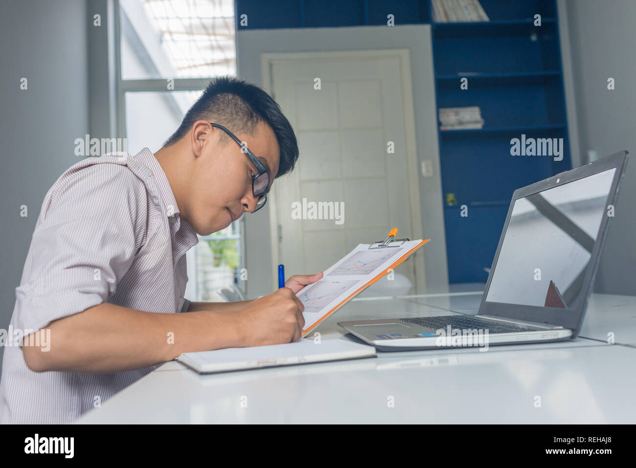 Side view of Asian office man writing note Stock Photo - Alamy
