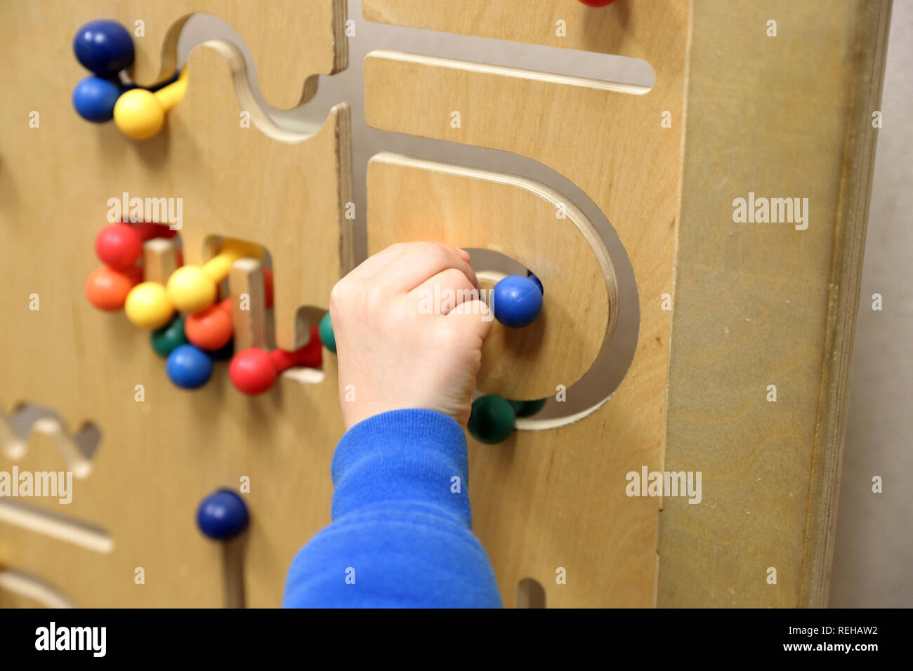 Child's hand plays with wooden educational toy used to learning sorting ...