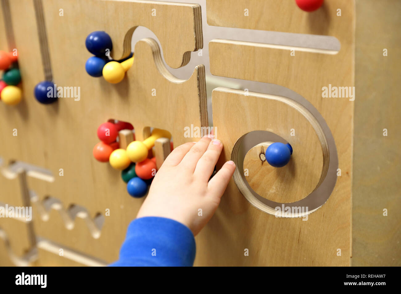 Child's hand plays with wooden educational toy used to learning sorting ...