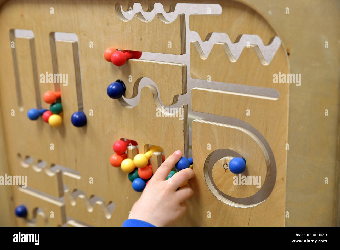 Child's hand plays with wooden educational toy used to learning sorting ...
