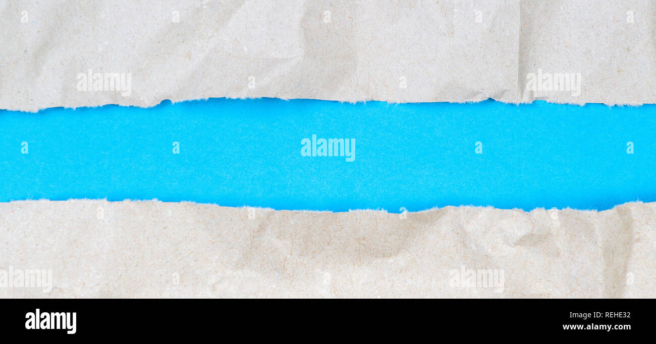 Gray package paper torn to reveal blue background with copy space Stock ...