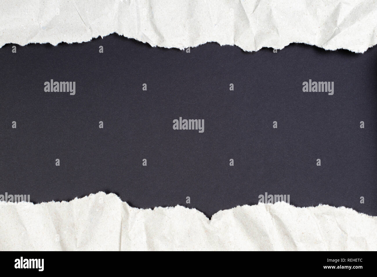 Crumpled package paper torn to reveal black background with copy space ...