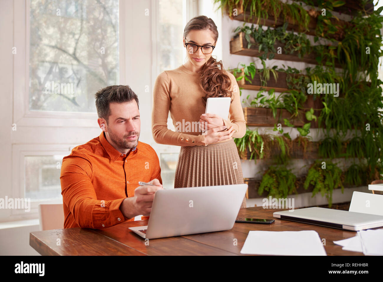 Shot of sales man and his smiling secretary businesswoman working ...