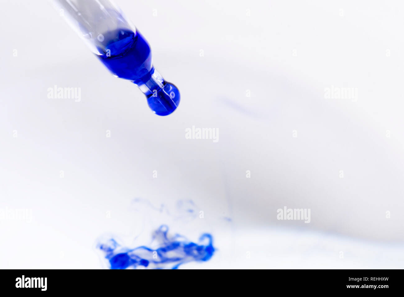 blue ink drips from a pipette into a light liquid Stock Photo - Alamy