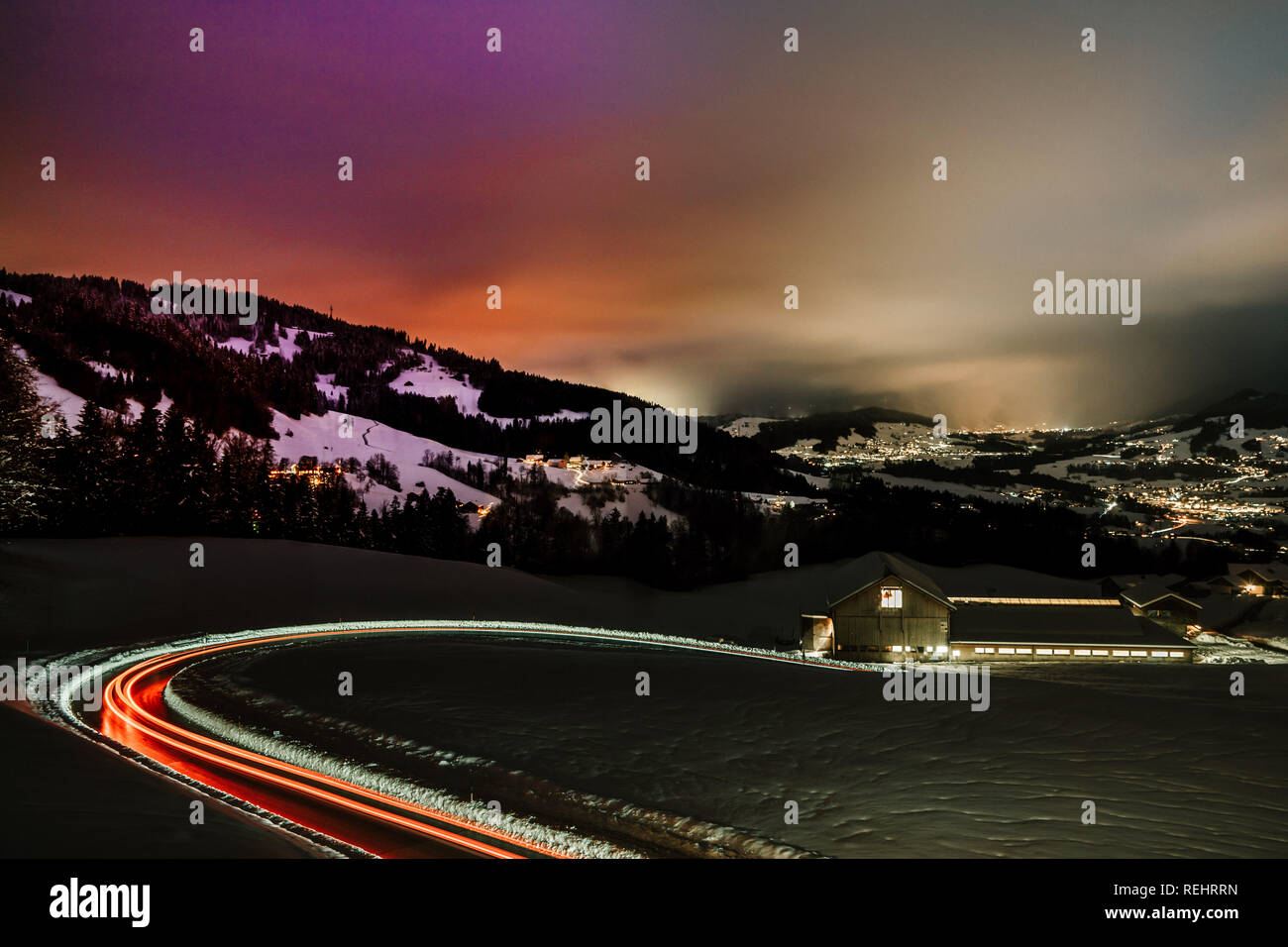 Long exposed night photography of cars driving through a snowy mountain ...