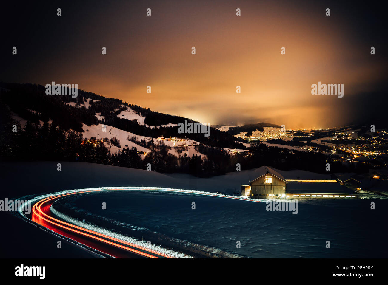 Long exposed night photography of cars driving through a snowy mountain ...