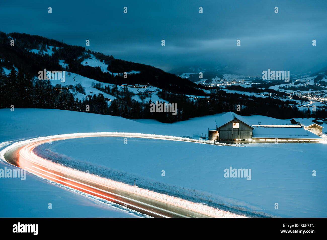 Long exposed night photography of cars driving through a snowy mountain ...