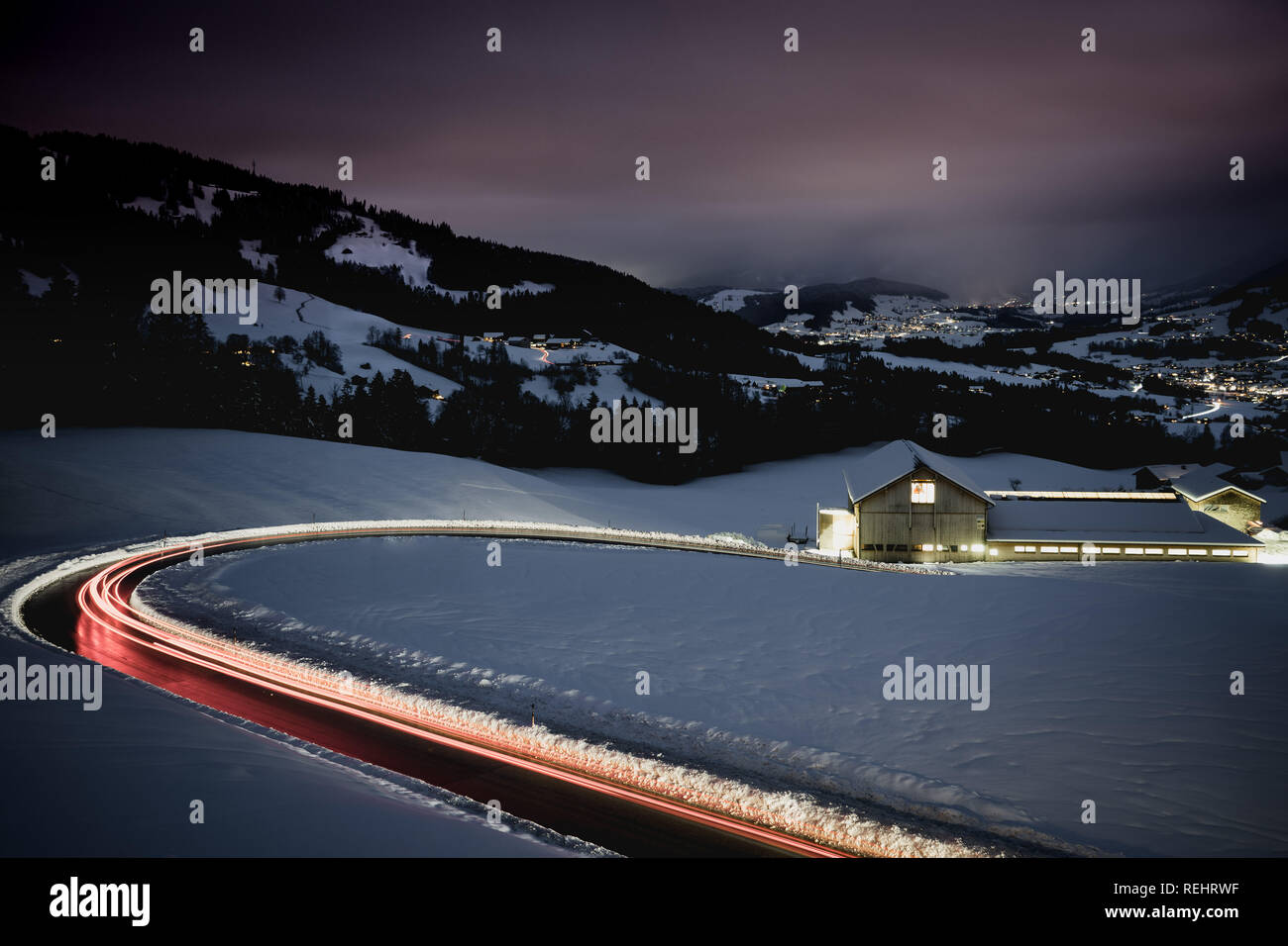 Long exposed night photography of cars driving through a snowy mountain ...
