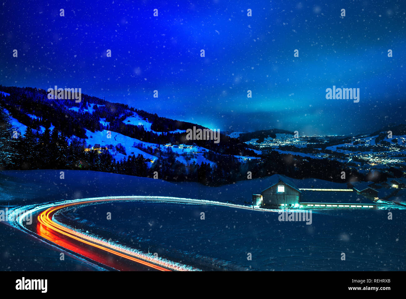 Long exposed night photography of cars driving through a snowy mountain ...