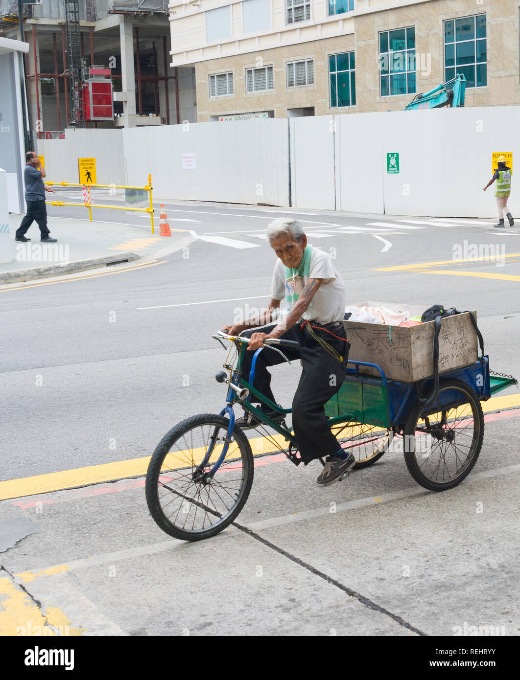 SINGAPORE - FEBRUARY 18, 2017: Man riding a tricycle on the road in ...