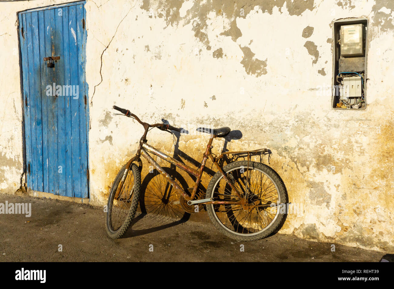 Old rustic vintage bicycle on the street near the color wall. Travel ...