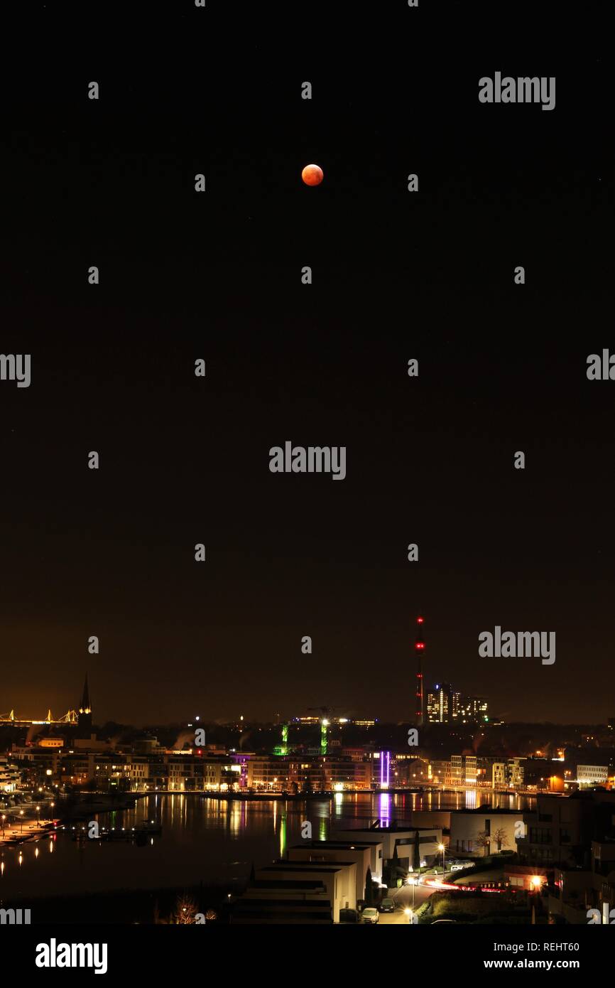 Total lunar eclipse over a city Stock Photo - Alamy