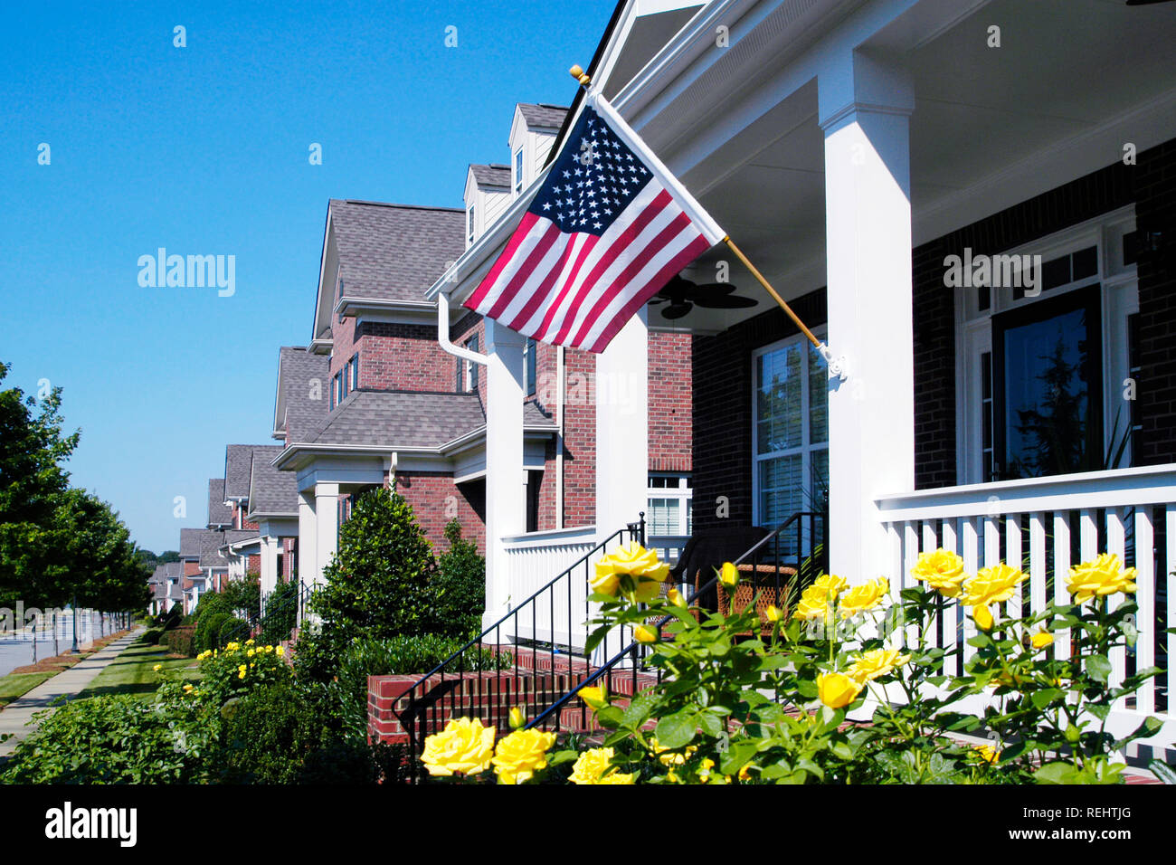 American Flags Hanging from Upscale Brick Home Stock Photo - Alamy