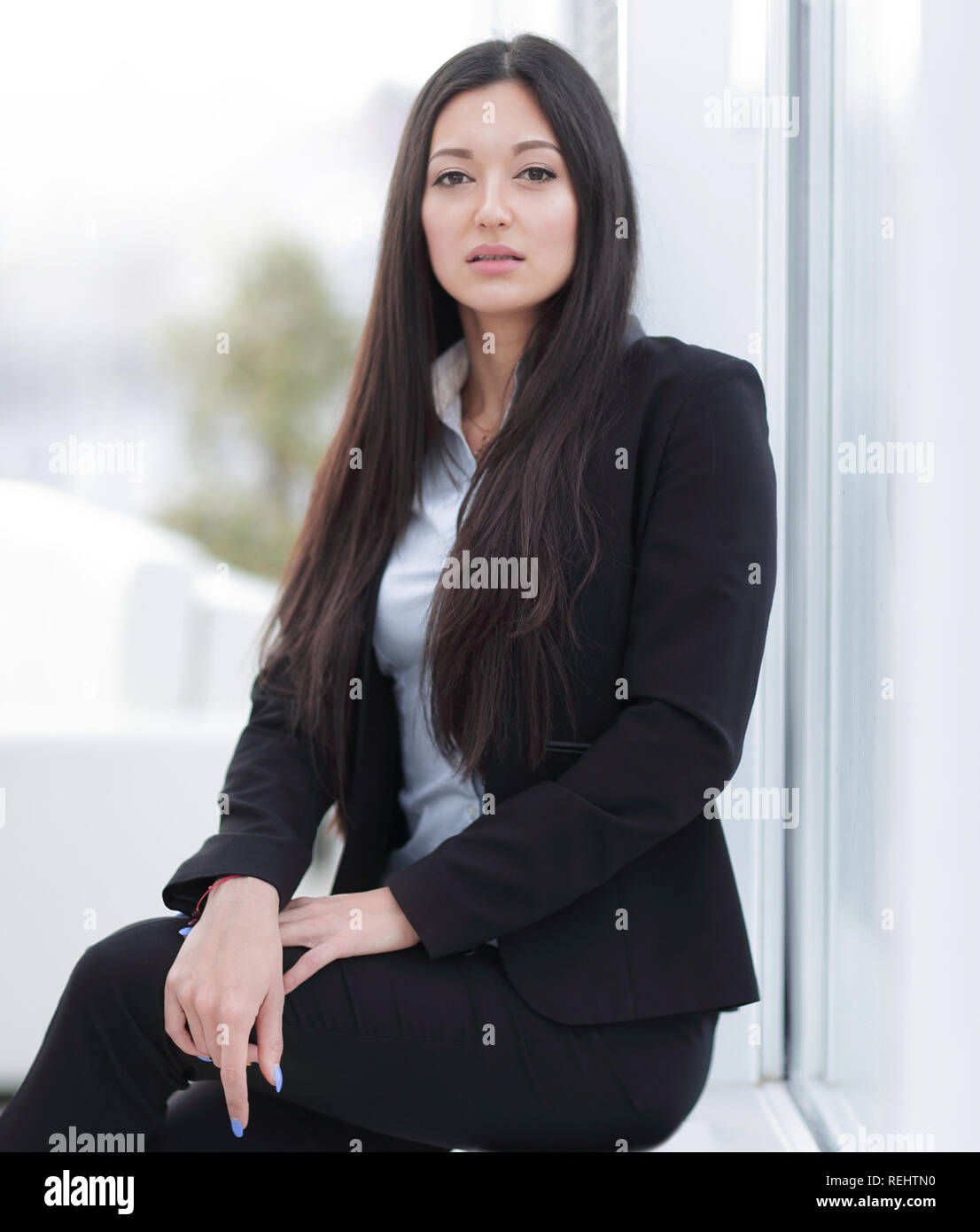 young employee sitting near a window in the office Stock Photo - Alamy