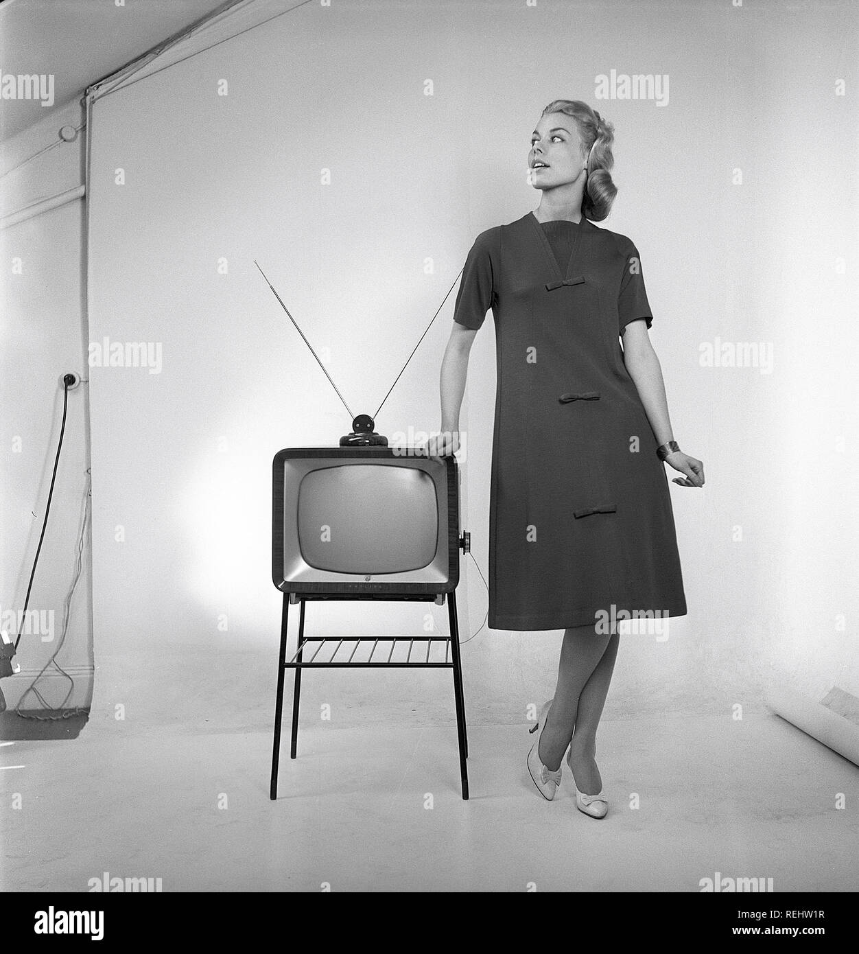 Television in the 1950s. A young woman is standing dressed in a typical ...