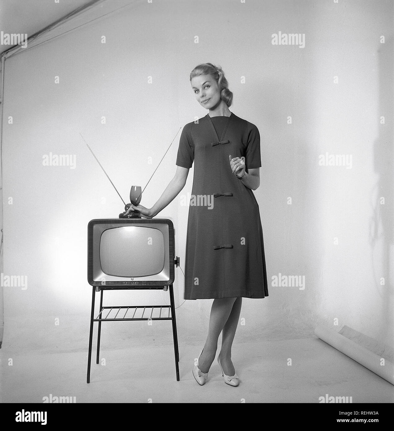 Television in the 1950s. A young woman is standing dressed in a typical ...
