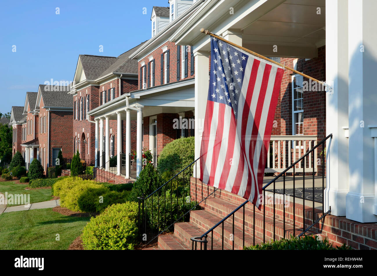 American Flags Hanging from Upscale Brick Home Stock Photo - Alamy