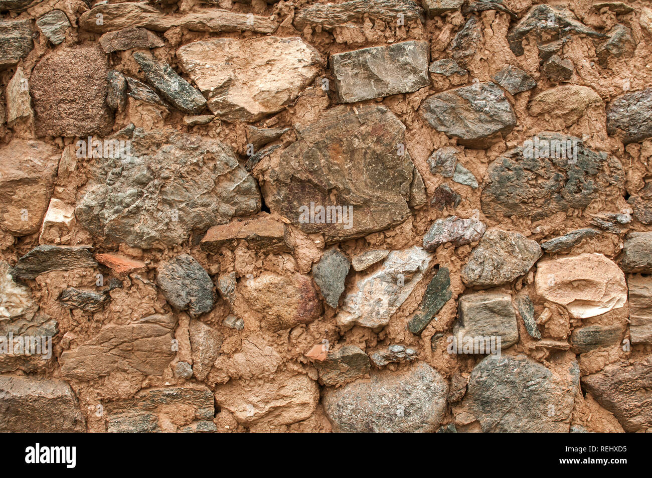 Old grunge weathered stone wall of rural farm house closeup as ...