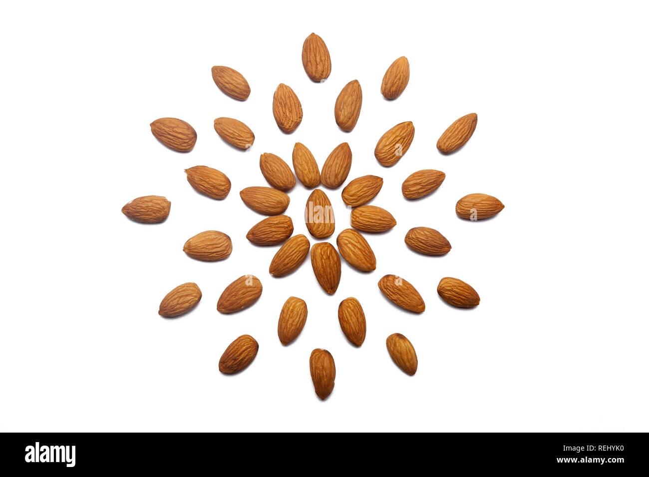 A collection of peeled almond nuts lies in the shape of a circle or sun ...