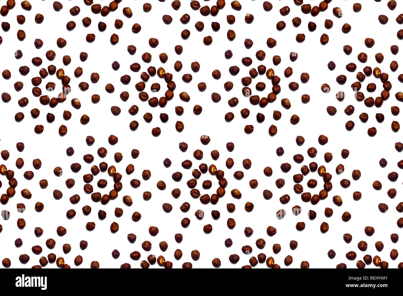 A collection of hazelnut nuts lie in the shape of a circle or sun on an ...