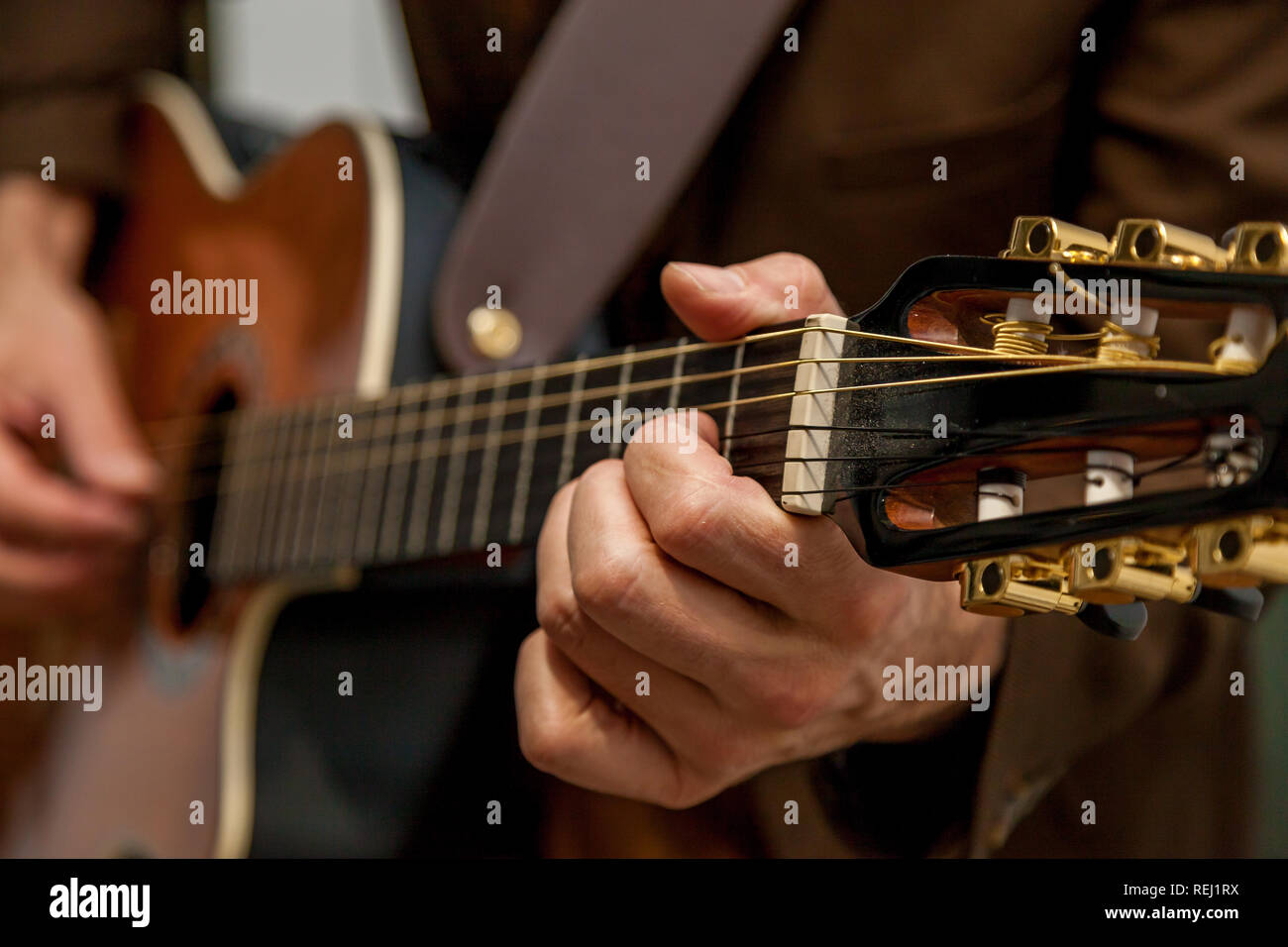 Close-up of the hands of a musician playing the guitar. The fingers of ...