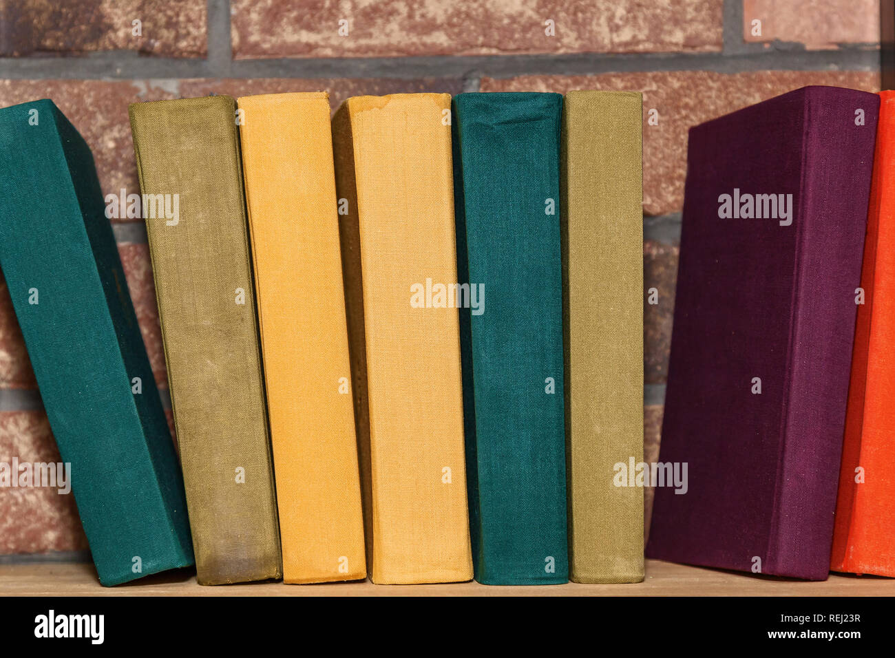 A row of old books with multi-colored covers are on the shelves Stock ...