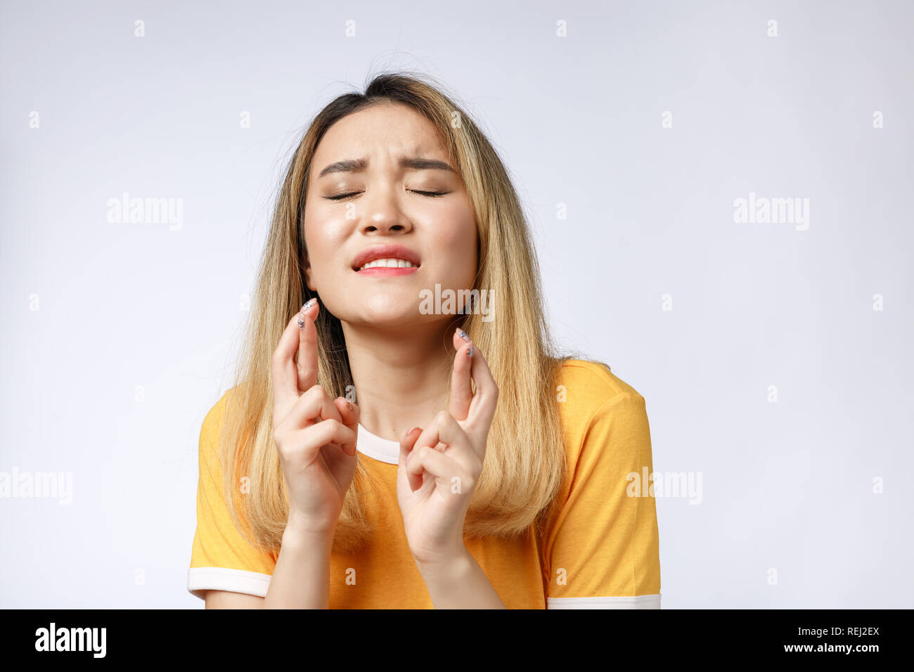 Portrait of praying young woman wearing casual clothing begging god ...