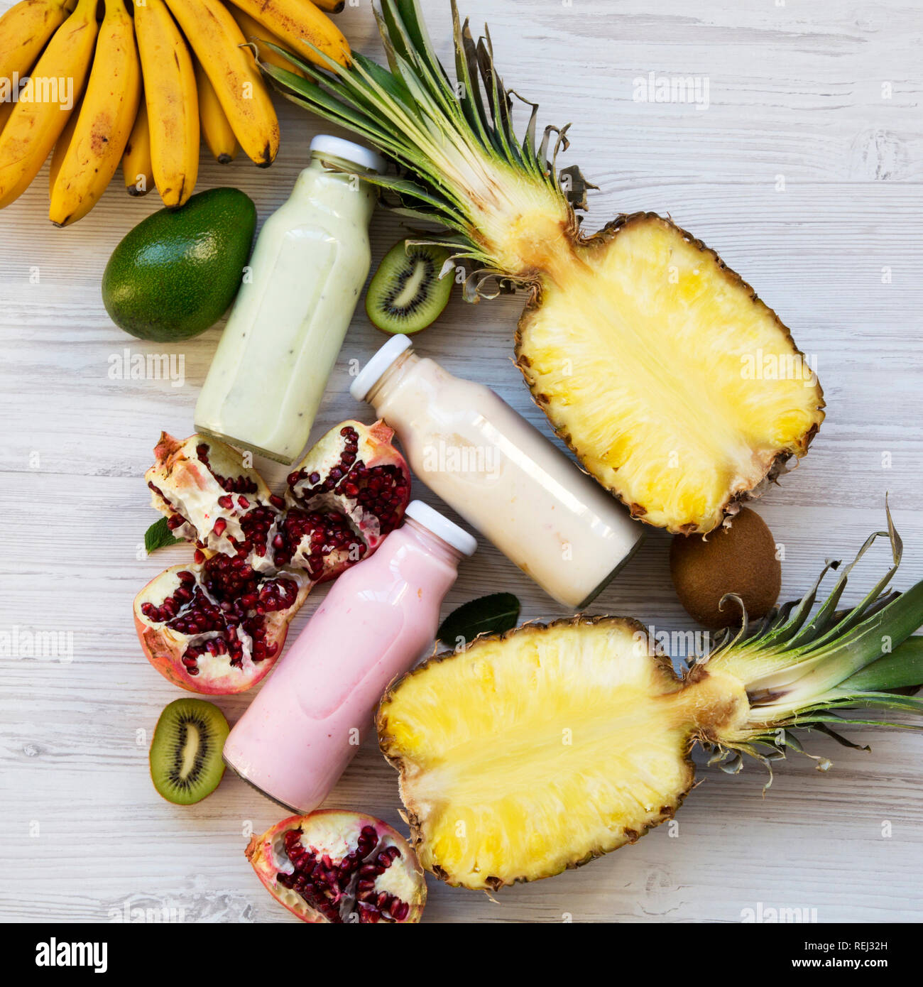 Fruit smoothies of different colors in glass jars with ingredients on ...