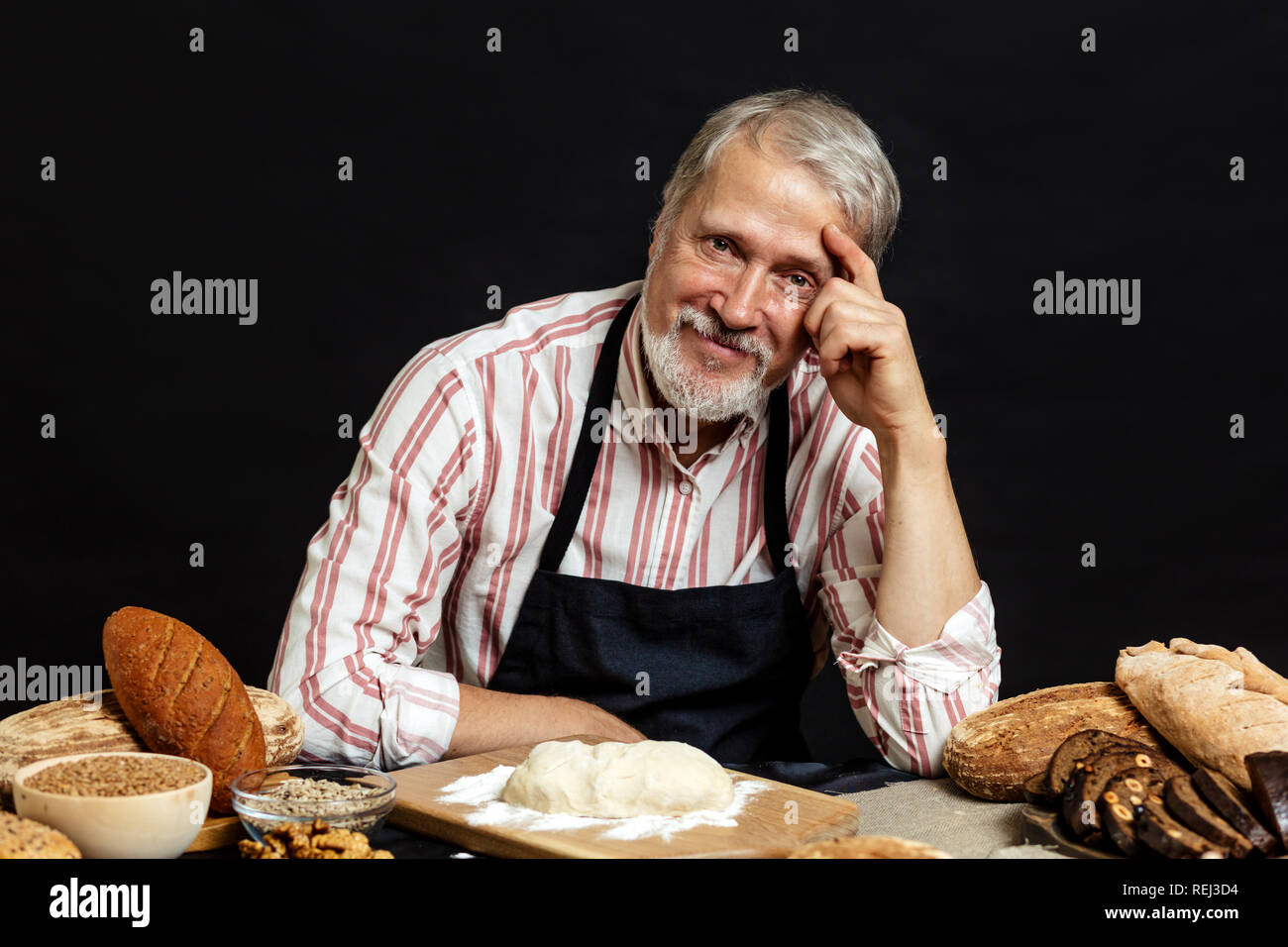 Elderly smiling professional chef man. Isolated over black background ...