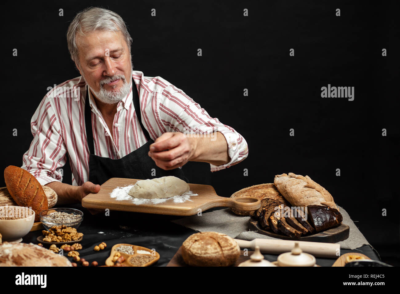 Mature bearded baker man kneading dough for bread on table Stock Photo ...