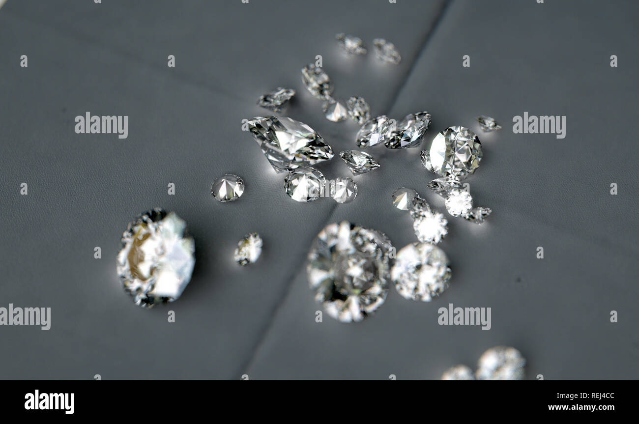A macro view of a collection of various sized cut diamonds on a dark ...