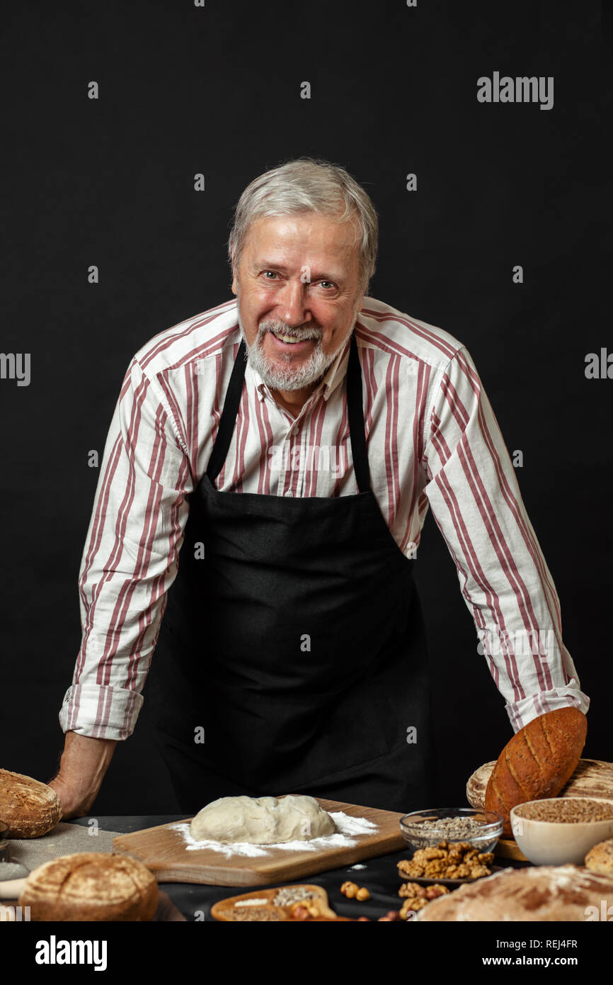 Male senior chef isolated on black background Stock Photo - Alamy