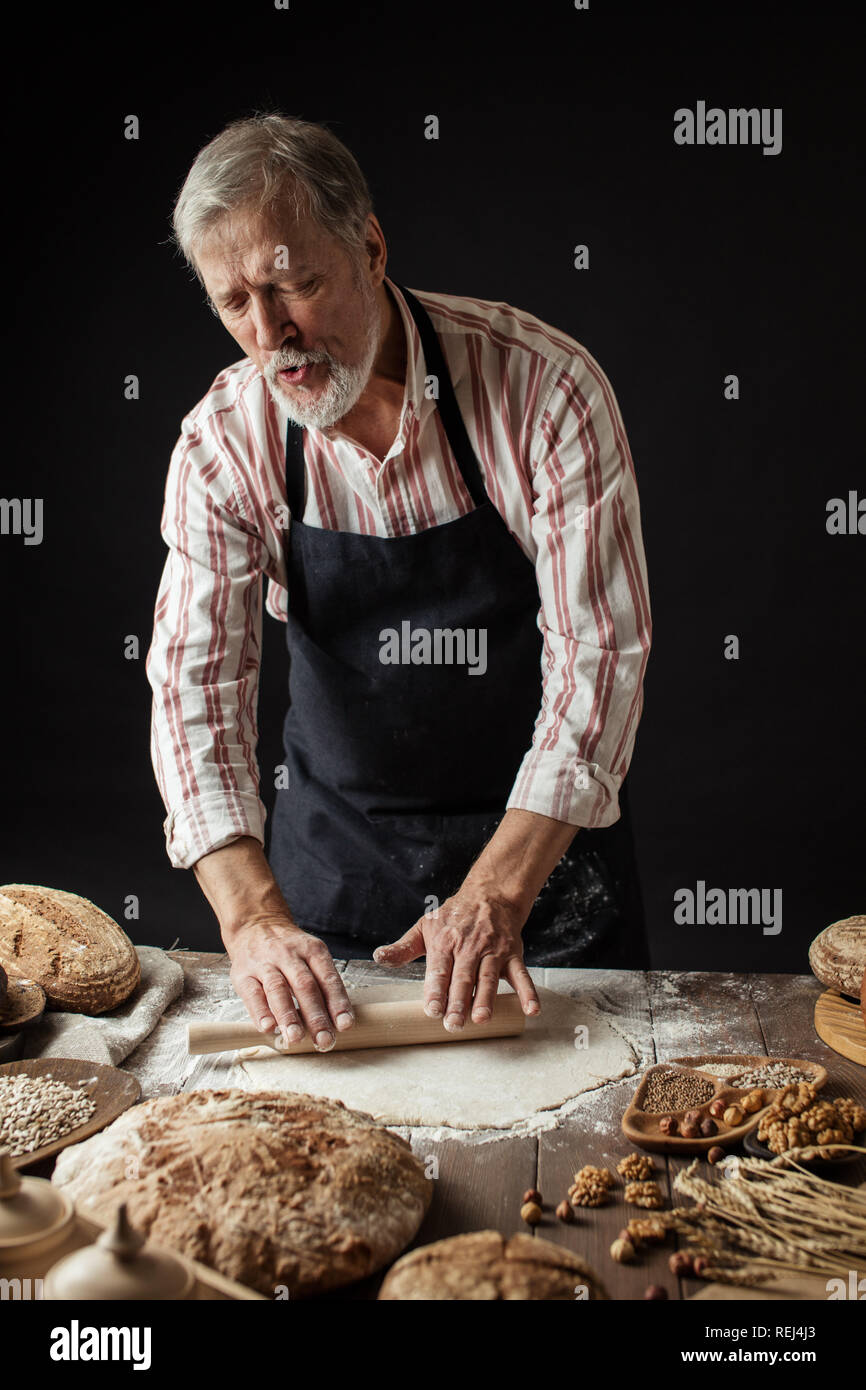 Experienced Baker Man preparing dough for homemade bread in the kitchen ...