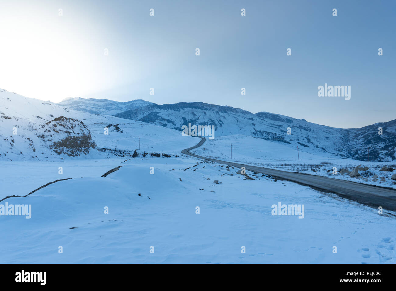 At a snowy mountain peak. Half of Mountain range covered with snow ...